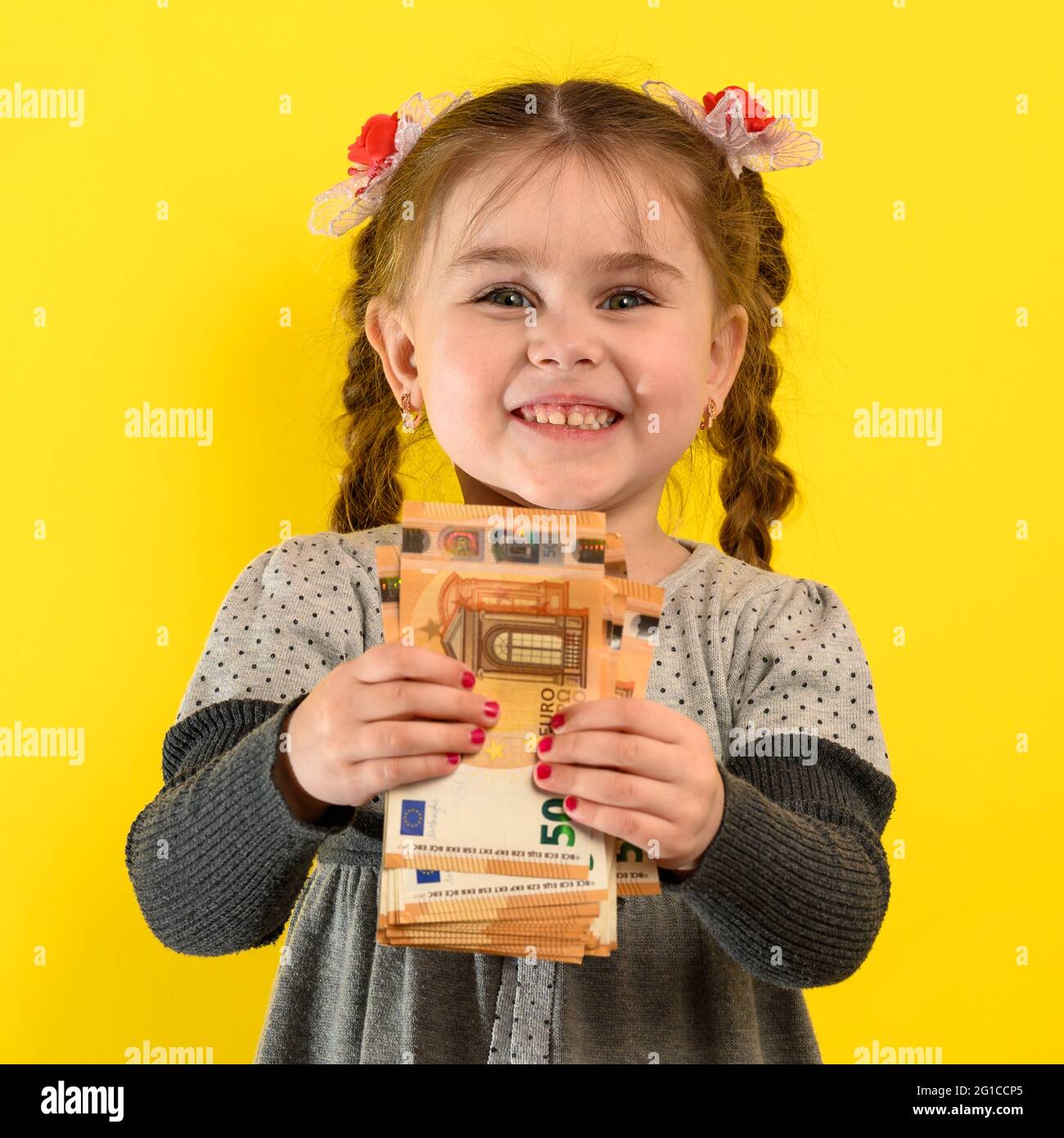 The girl is holding euro bills in denominations of 50 euros, a child ...