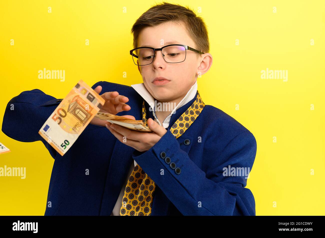 The child scatters money, a boy in a suit throws euros, a portrait of a ...