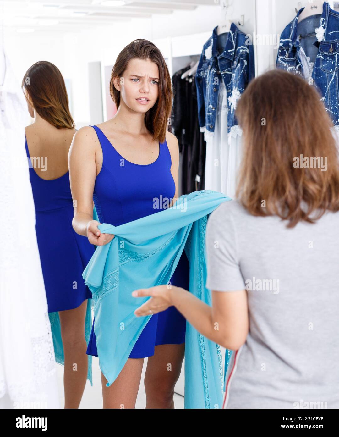 Angry woman trying to choose clothes Stock Photo - Alamy