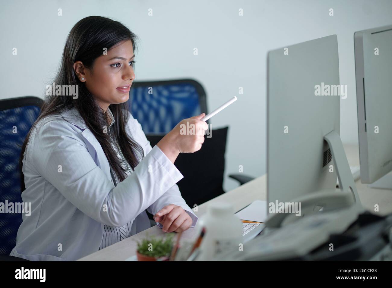 Young scientist or medical laboratory worker pointing at computer ...