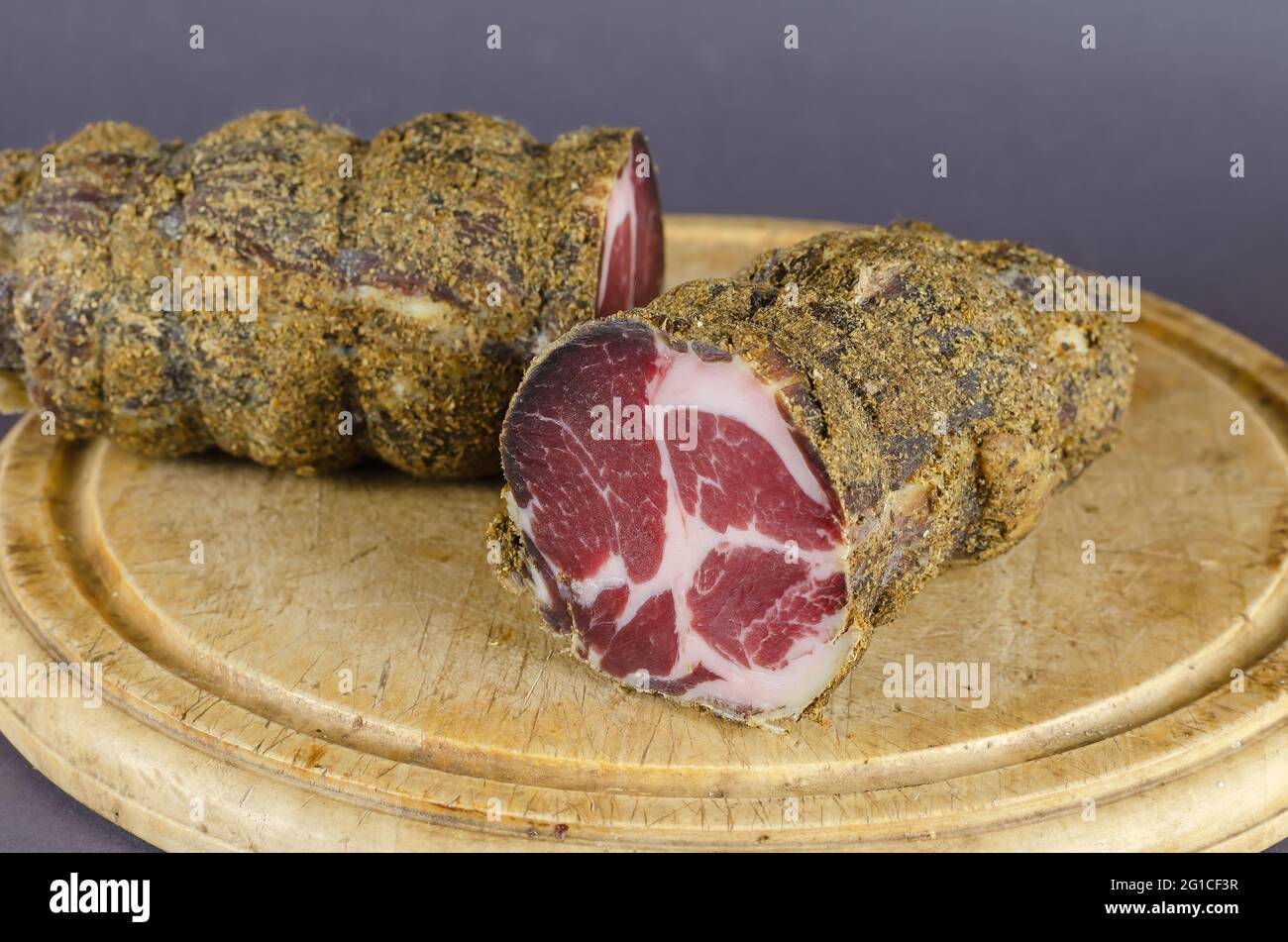 Cured meat, pork neck, coppa. A piece of appetizing air-dried pork on a ...