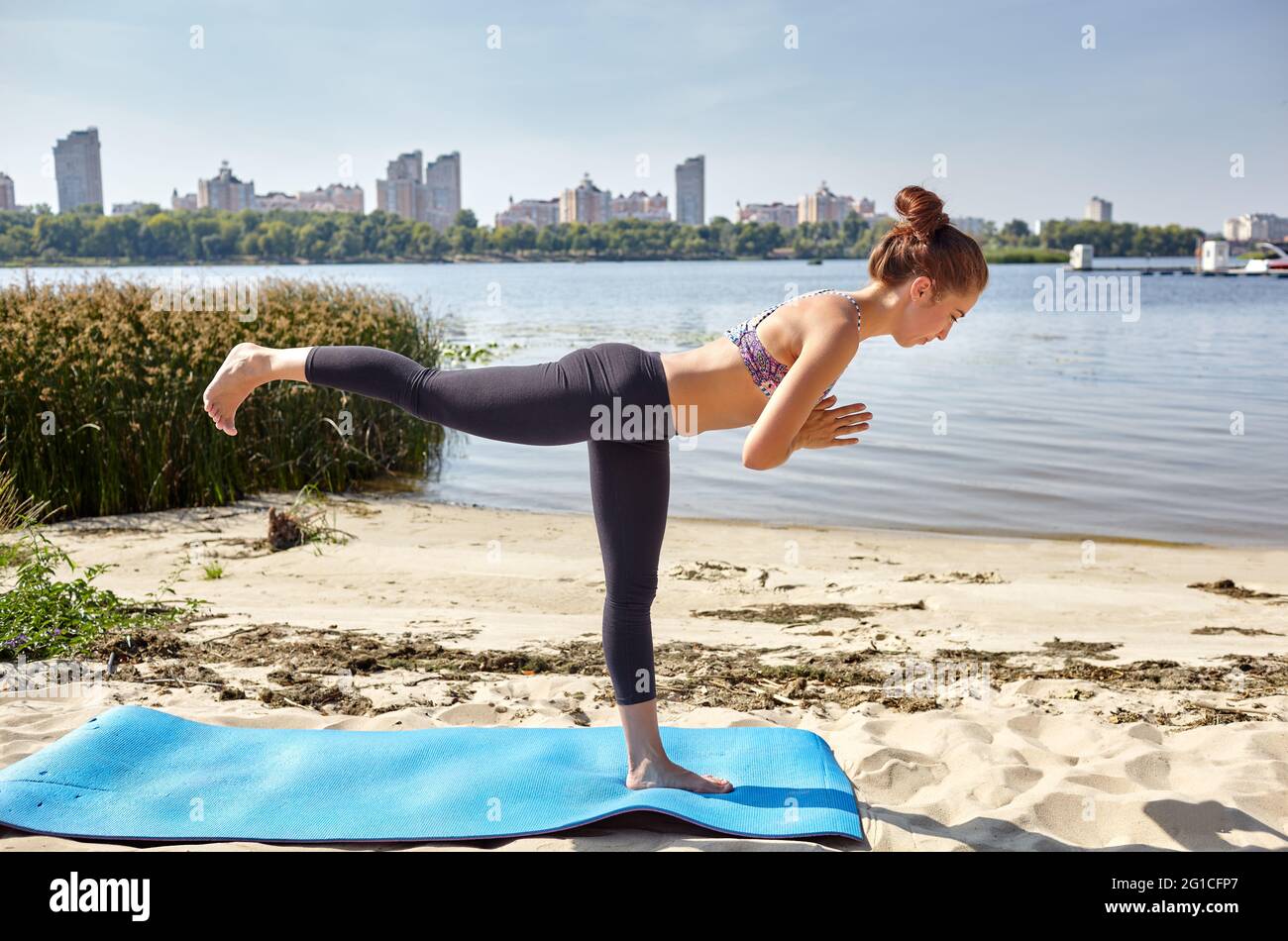 woman performing asanas and enjoying life on the sea. Yoga on the beach ...