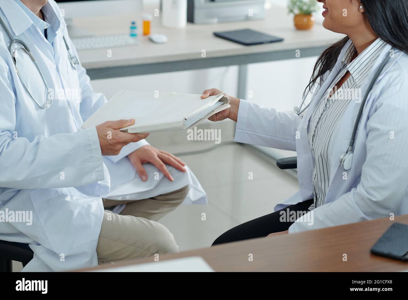 Doctor giving patient documents hi-res stock photography and images - Alamy
