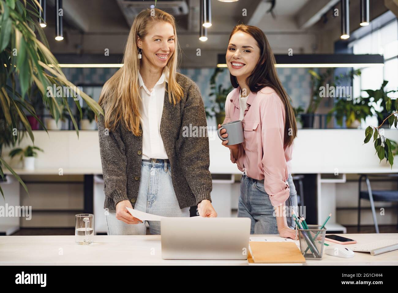 Two young women working together in office Stock Photo - Alamy