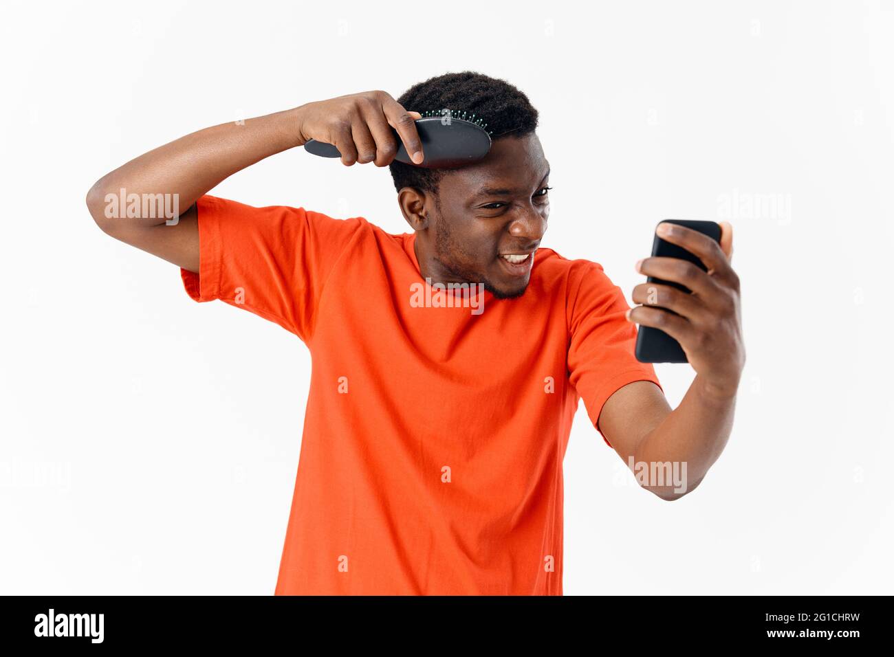 African American combing afro hairstyle dissatisfied phone in hand ...