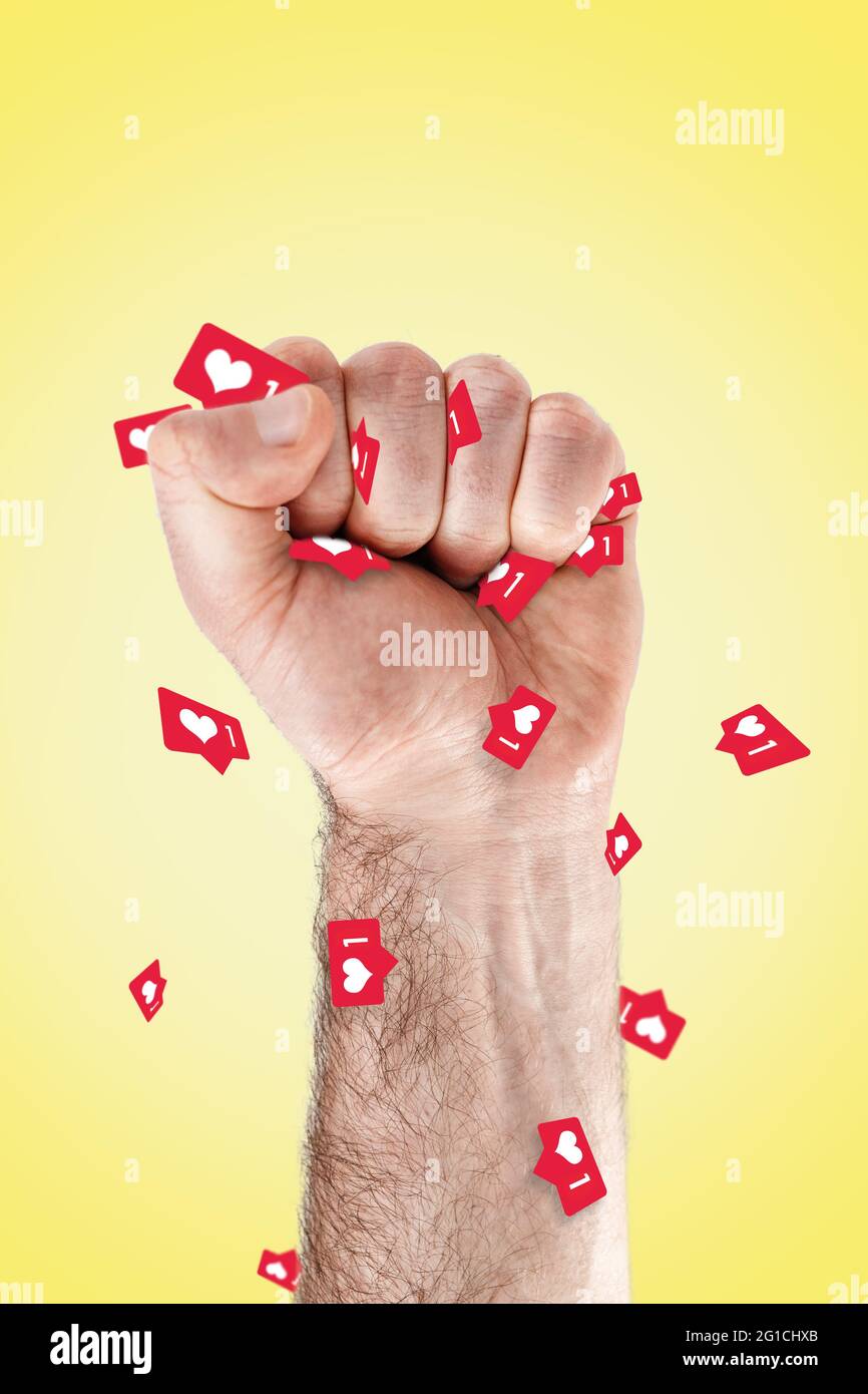 A man's hand holds icons of hearts from social networks in his fist ...
