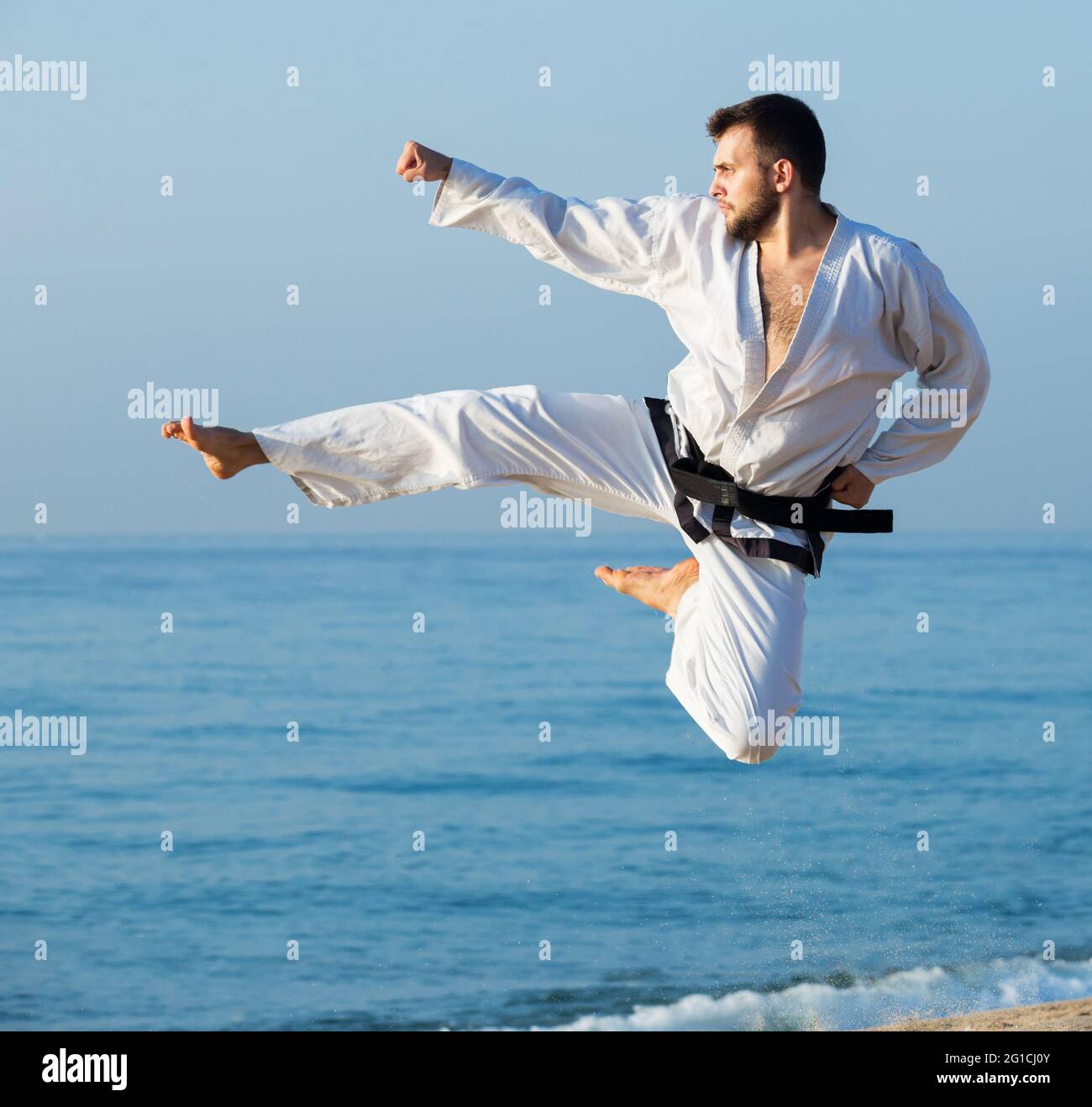 Guy practising karate at seaside Stock Photo - Alamy
