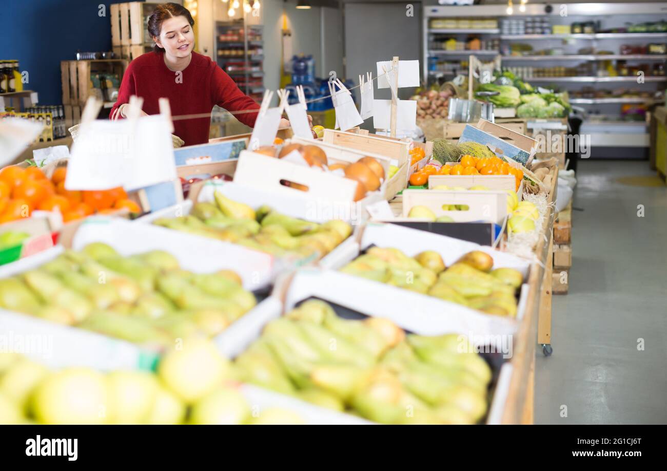 Positive young customer selecting fruits Stock Photo - Alamy