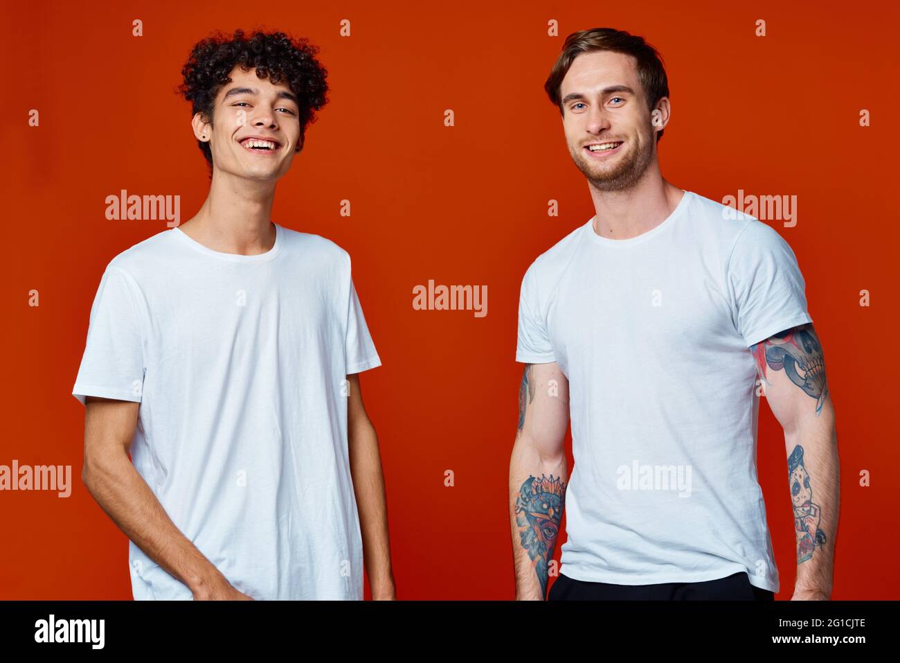two men in white t-shirts on a red background friendship Stock Photo ...