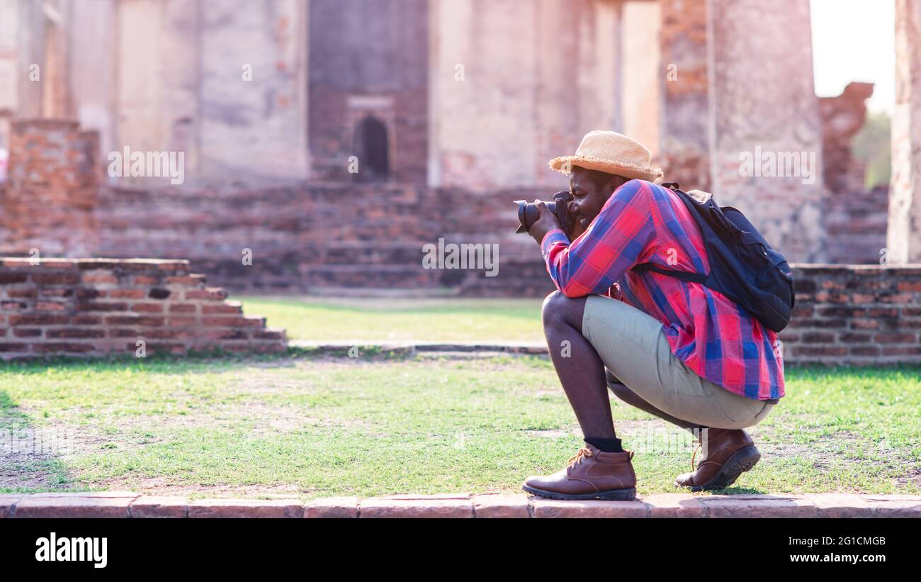 African male photographer enjoying to taking pictures of ancient ...