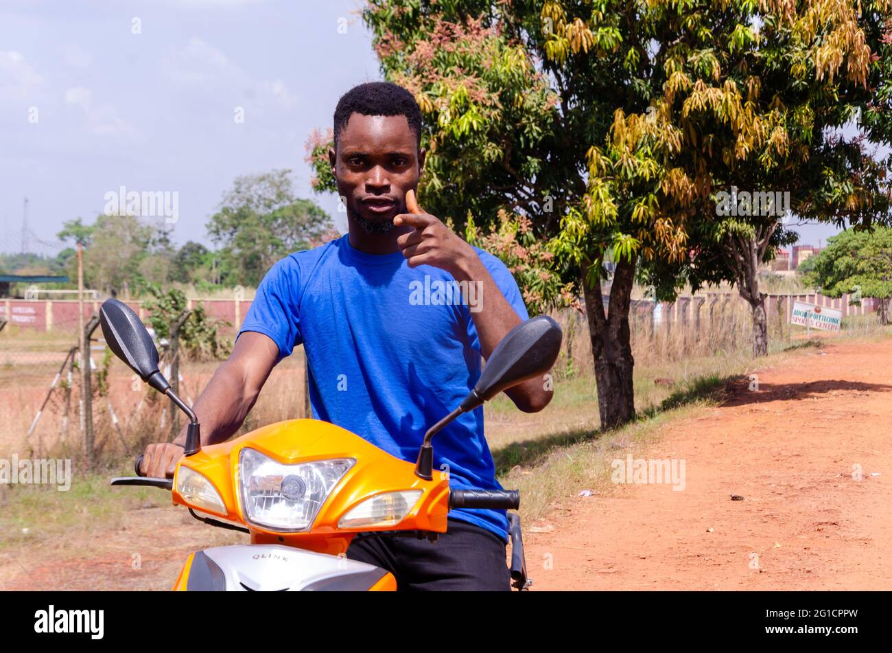 young excited african motorcyclist pointing Stock Photo - Alamy