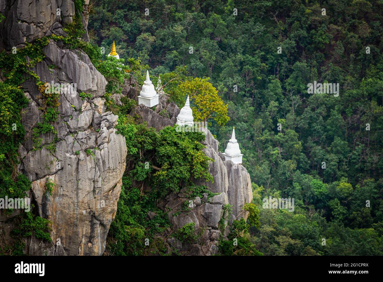 White pagoda and stupa on top of mountain cliff in woodland called Wat ...