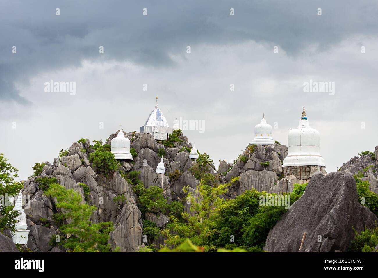 White pagoda and stupa on top of mountain cliff in woodland called Wat ...