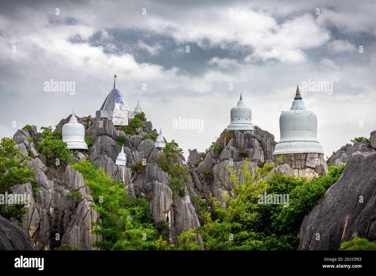 White pagoda and stupa on top of mountain cliff in woodland called Wat ...