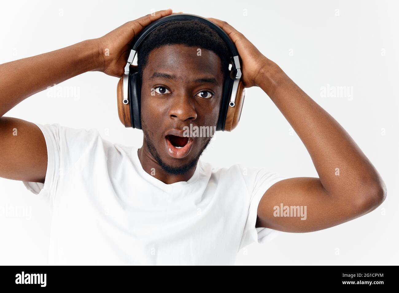 man with surprised facial expression in headphones listening to music ...