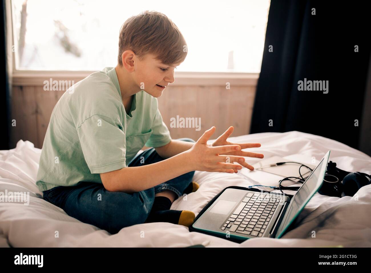Boy attending video call while E-learning at home Stock Photo - Alamy