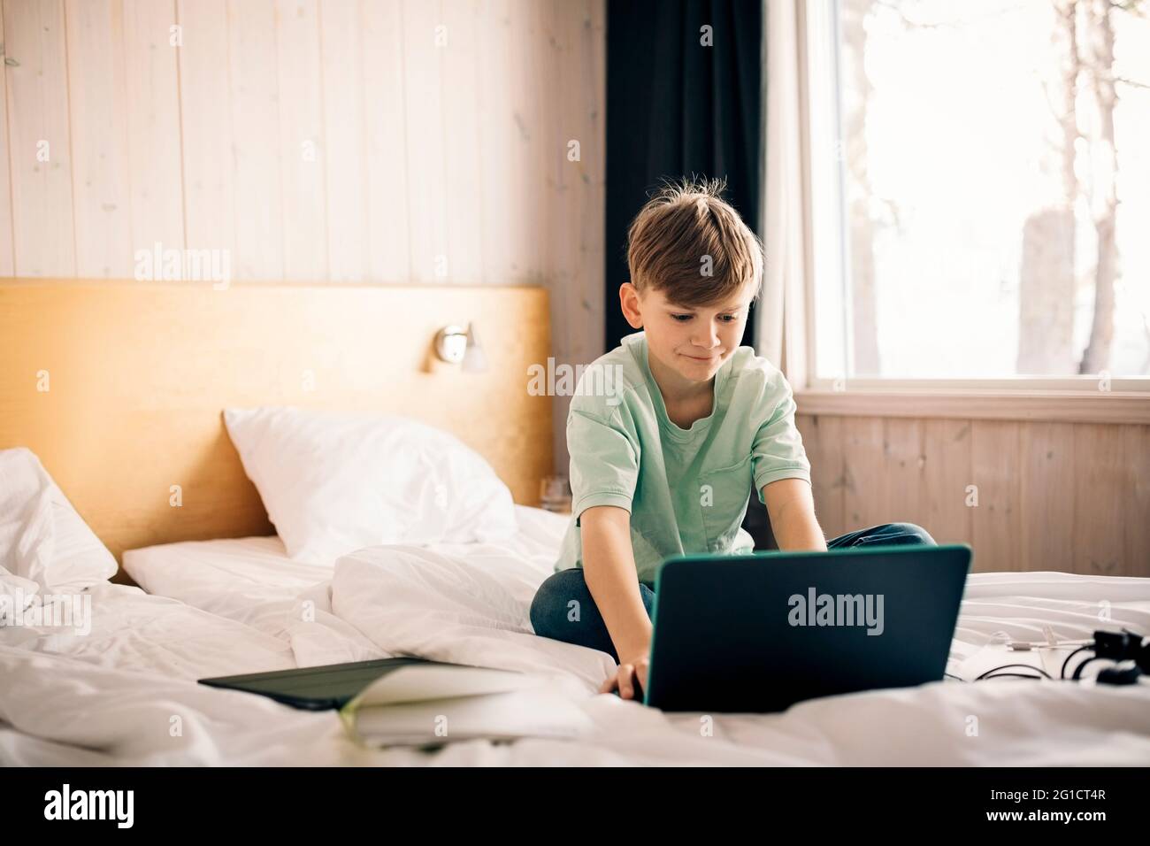 Boy using laptop while studying at home Stock Photo - Alamy