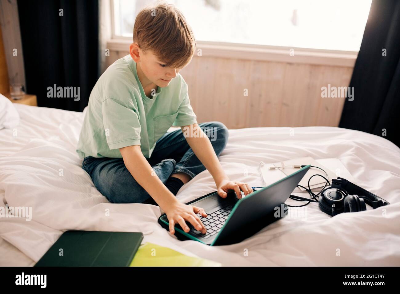 Boy E-learning through laptop at home Stock Photo - Alamy
