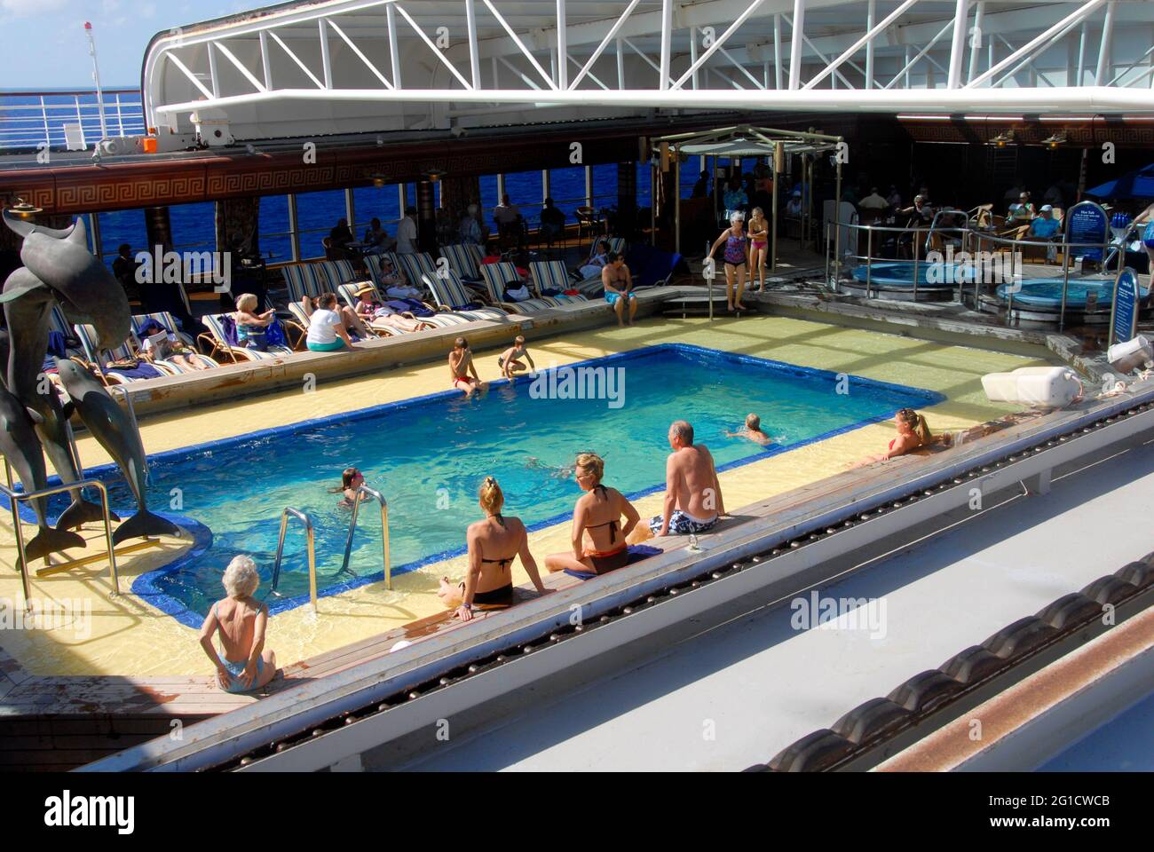 Passengers around the covered pool on a cruise liner with the roof ...