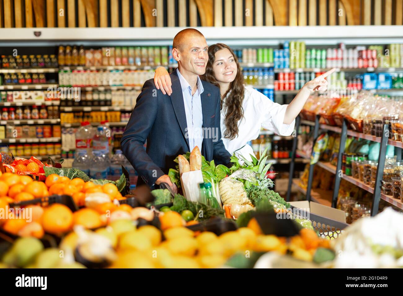Wife points out something to her husband at grocery store Stock Photo ...
