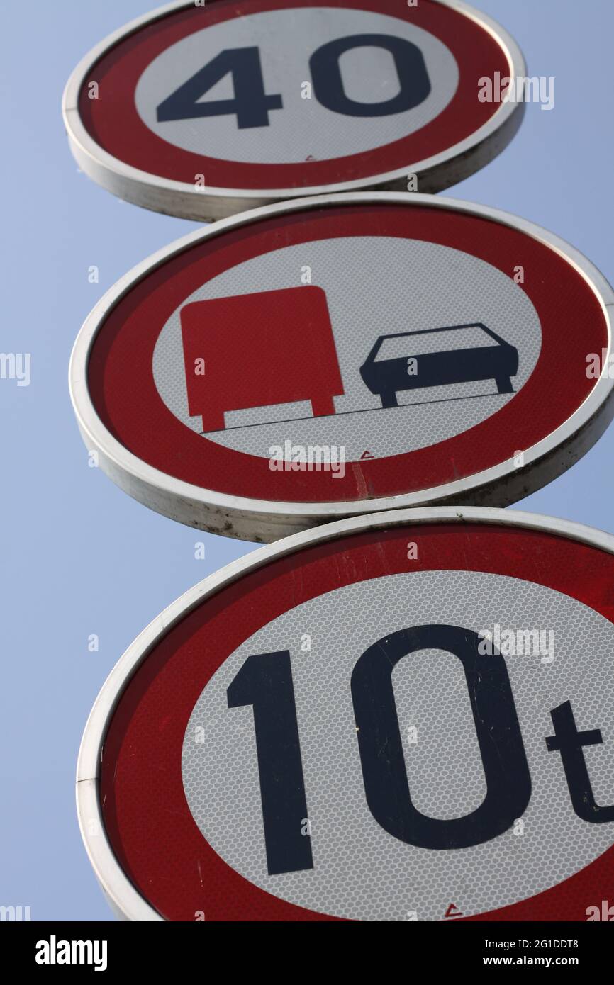 Vertical shot of three traffic signs on a blue background Stock Photo ...