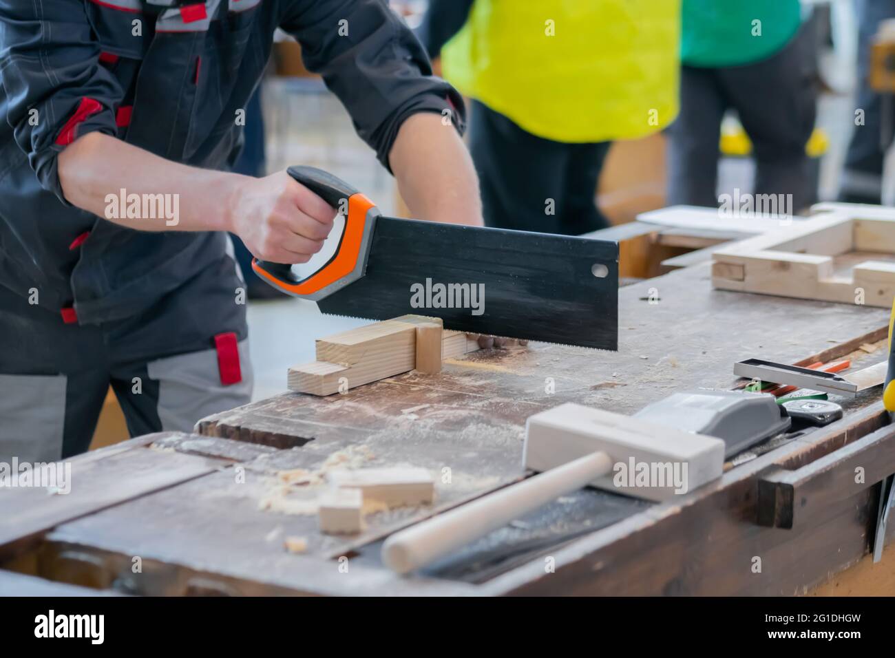 Man carpenter using hand saw to cutting wood on workbench - close up ...