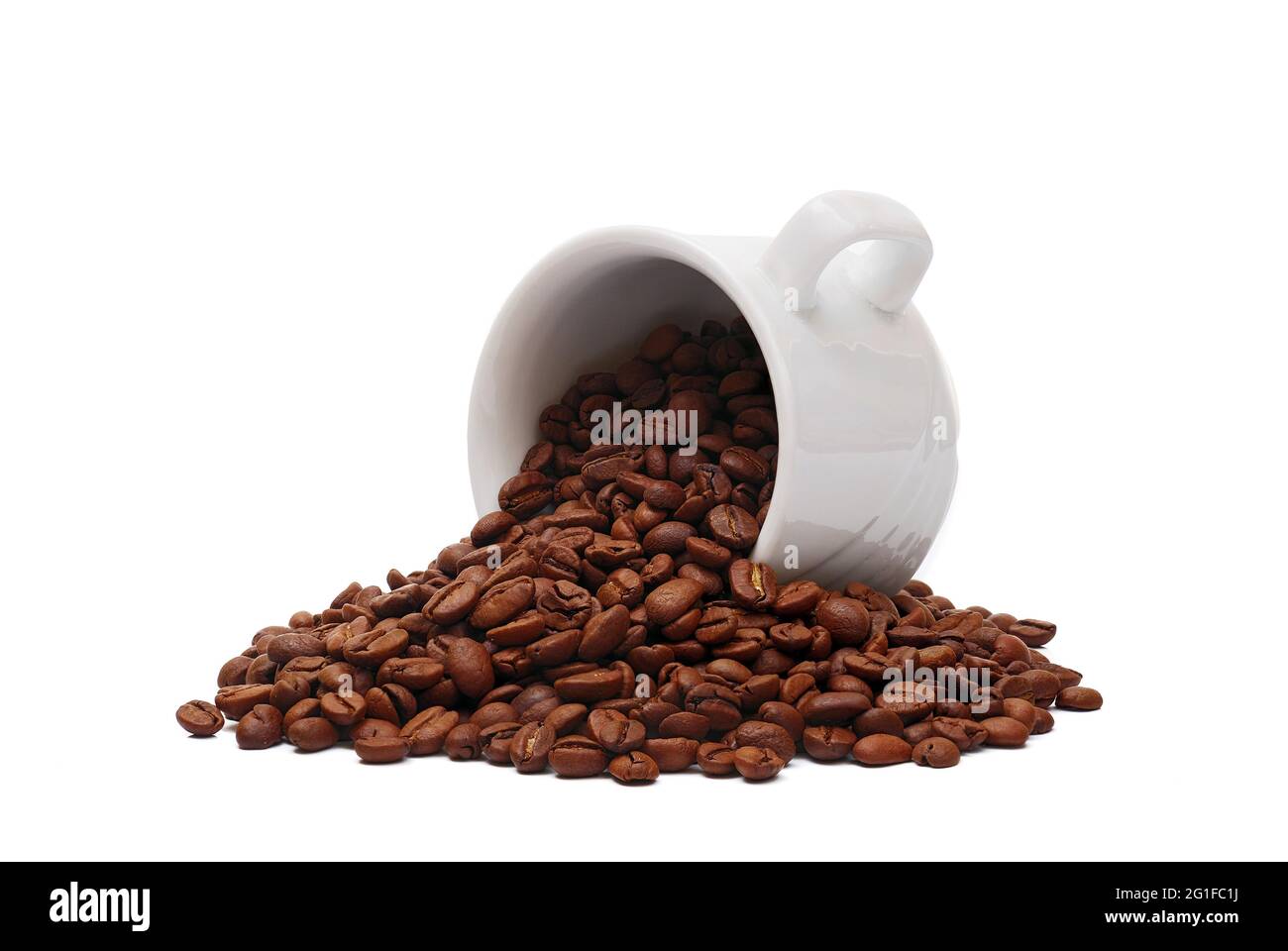 overturned white coffee cup overfilled with roasted coffee beans ...