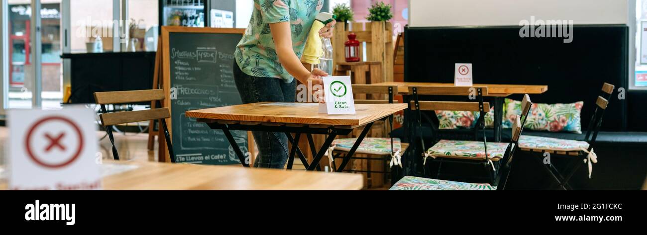Waitress placing sign on coffee shop tables Stock Photo - Alamy