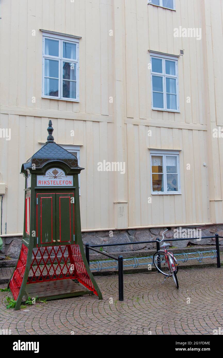 Old Swedish telephone box Rikstelefon in front of white wooden facade ...