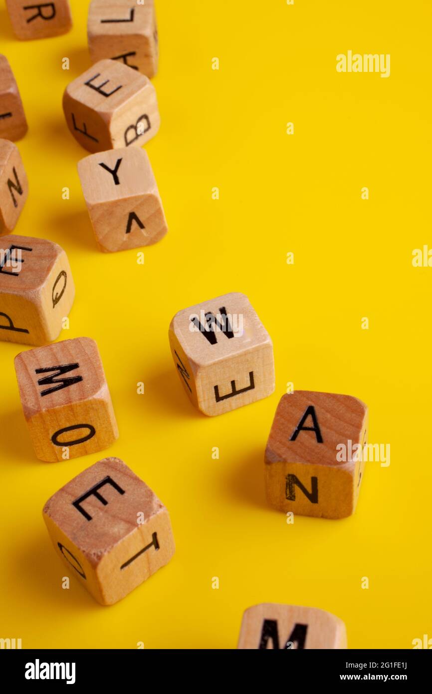 Wooden letter dices alphabet on yellow background Stock Photo - Alamy