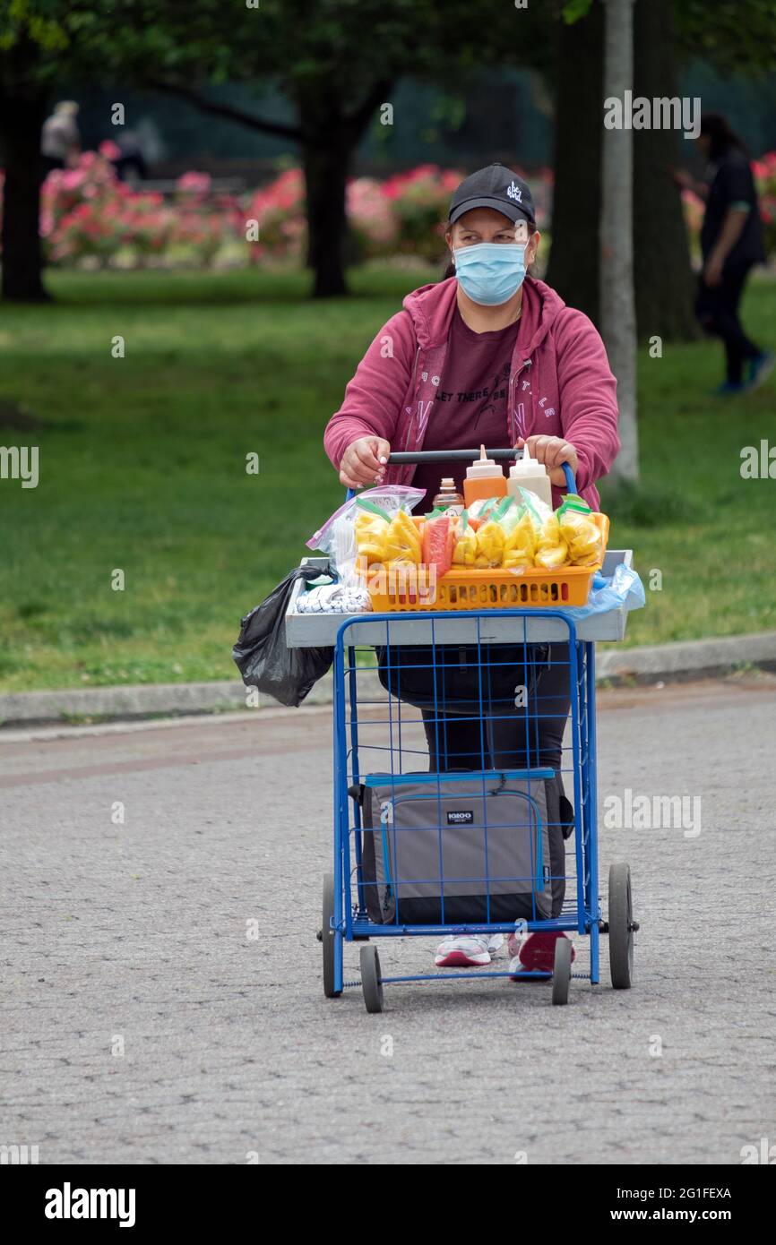 A middle aged woman, likely South american, selling mango slices in ...
