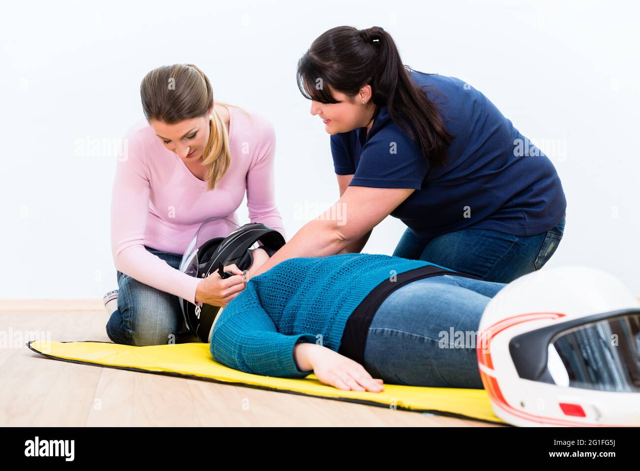 First aiders in class practicing to remove the helmet of injured biker ...
