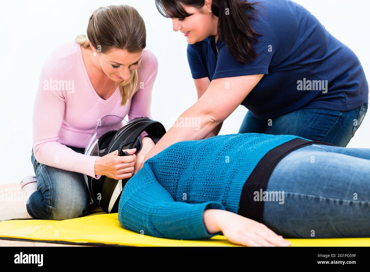 First aiders practicing to remove the helmet of injured biker in first ...