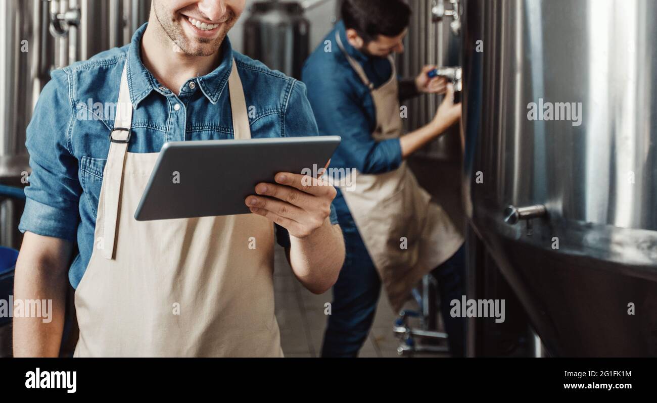 Beer production process at brewery. Man operating brewing equipment at ...