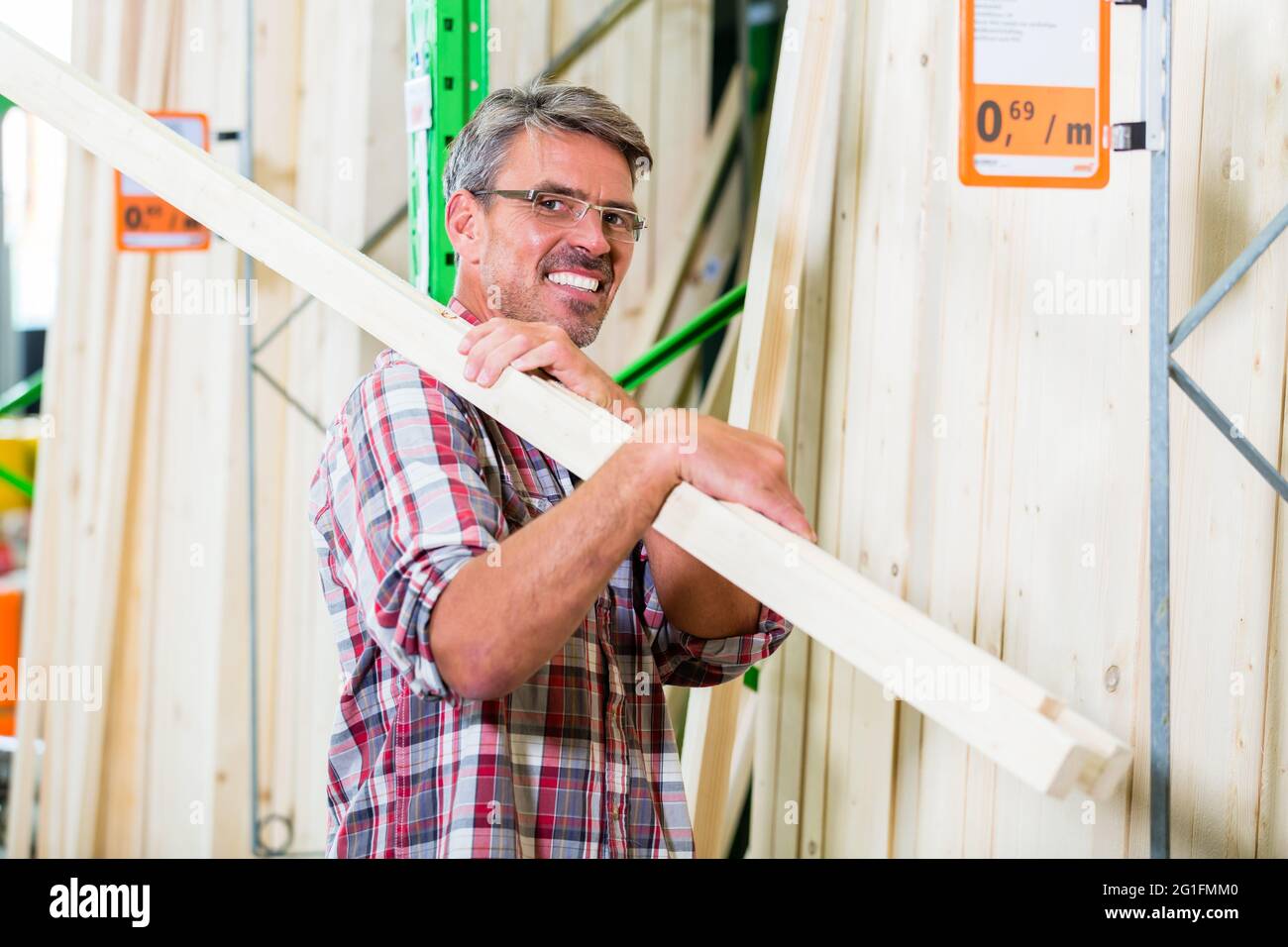 Customer in lumber department of hardware store choosing wood strip for ...