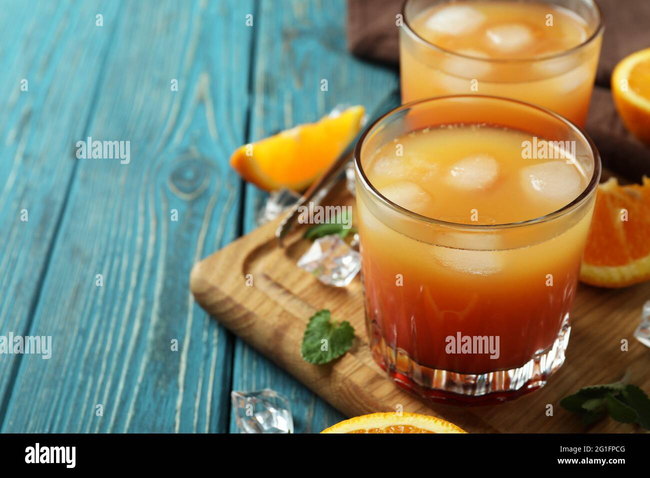Tequila Sunrise cocktails and ingredients on wooden table Stock Photo ...
