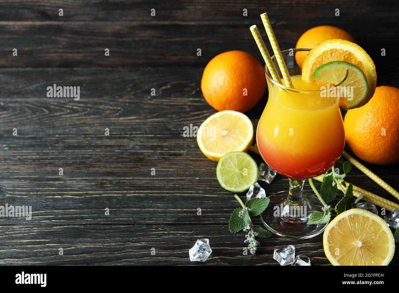 Tequila sunrise cocktail and ingredients on wooden table Stock Photo ...