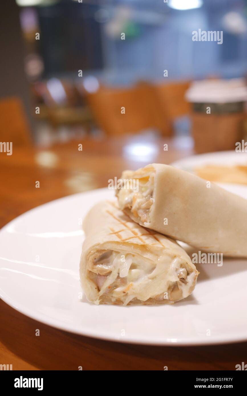 Cheesy chicken warp on cafe table Stock Photo - Alamy