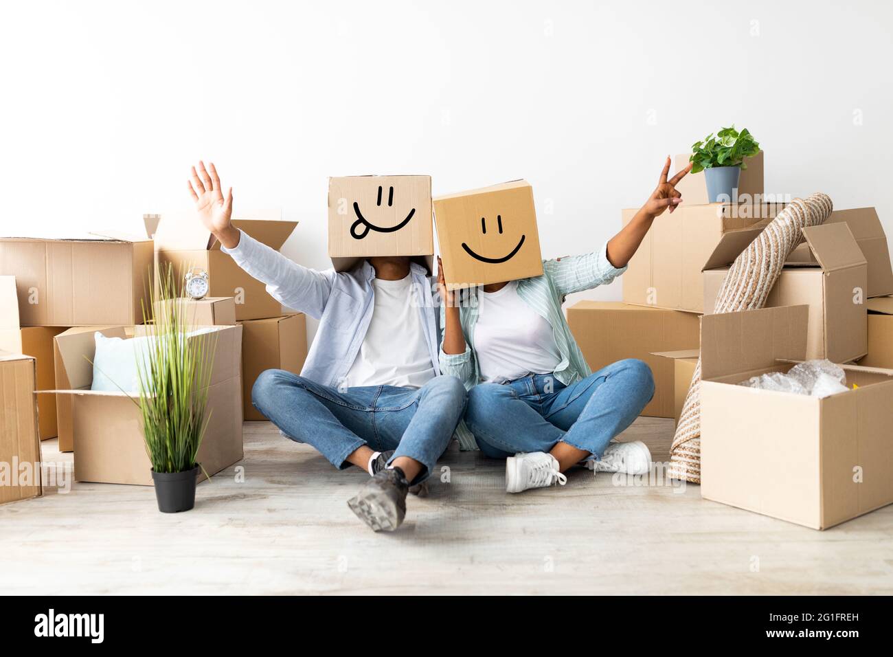 Moving house concept. Playful couple with cardboard boxes with smiley ...