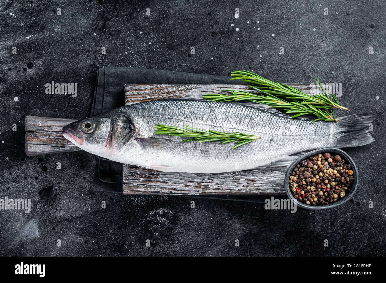 Fresh Raw seabass or sea bass fish on a wooden board ready for cooking ...