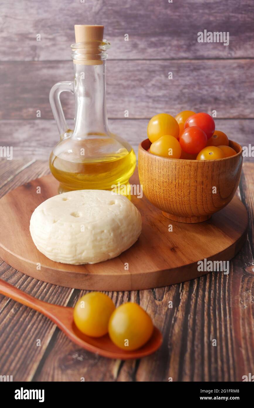 cherry tomato, cheese and olive oil on table Stock Photo - Alamy