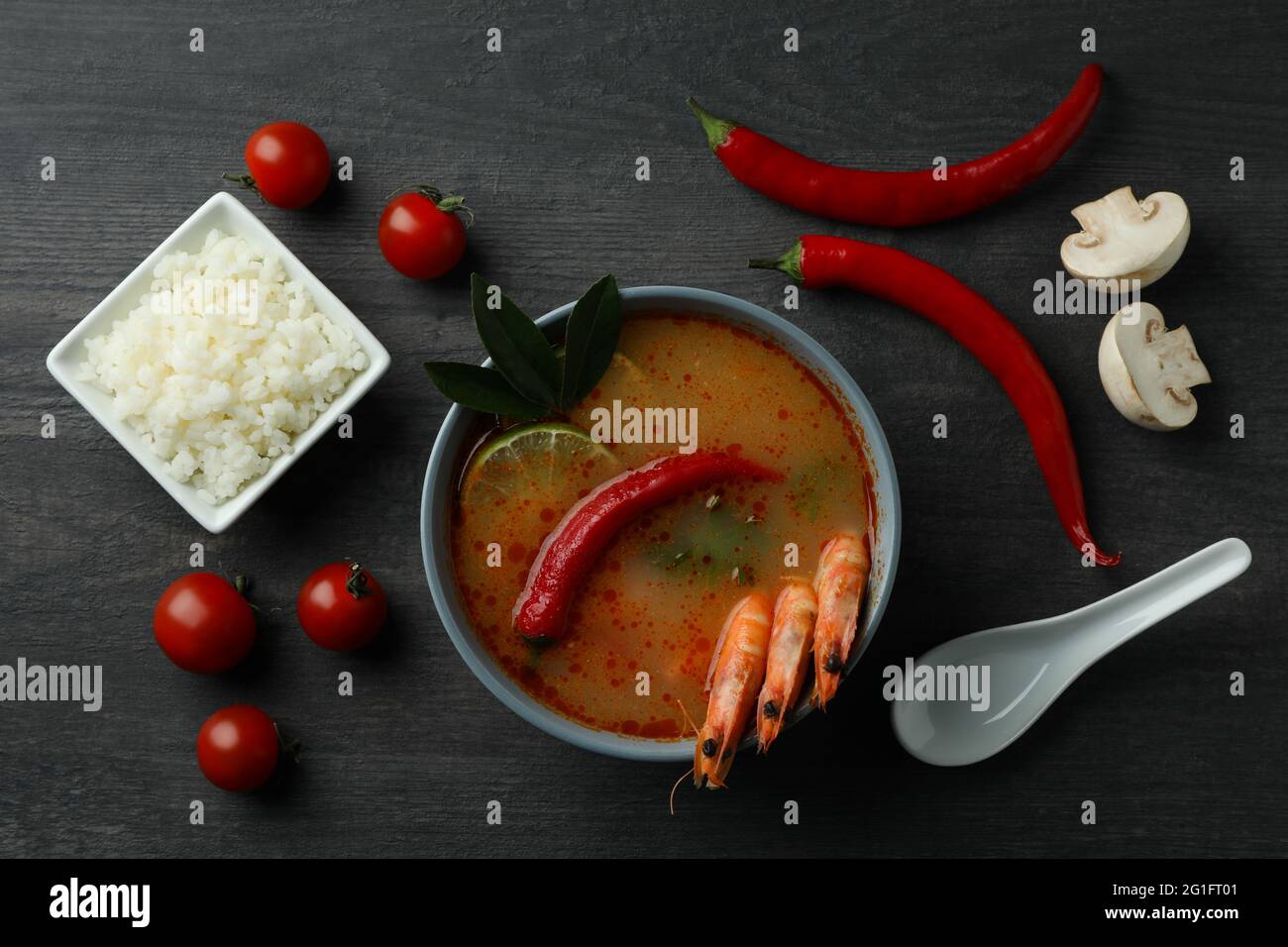 Tom yum soup and ingredients on dark wooden background Stock Photo - Alamy