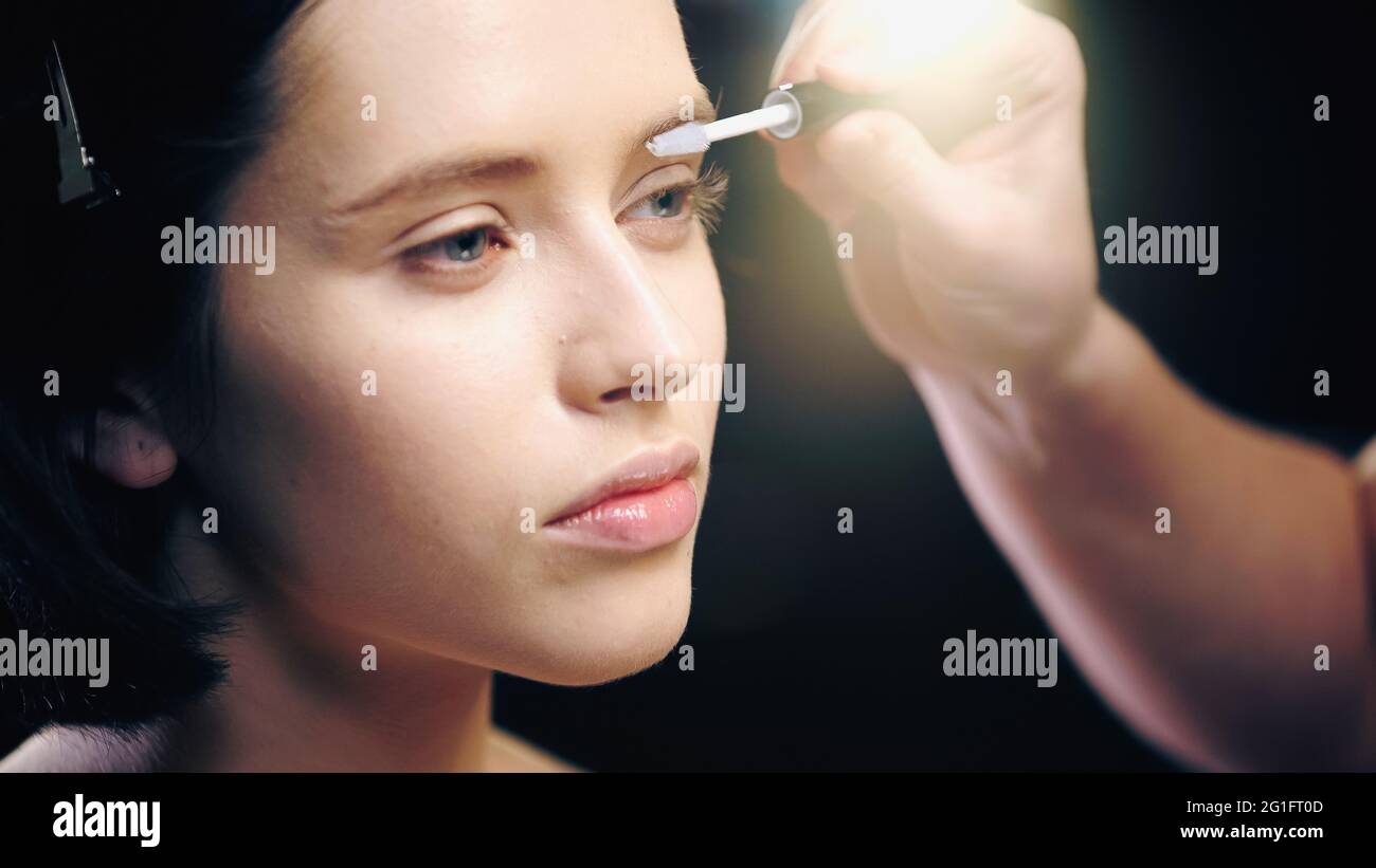 makeup artist brushing eyebrow of model Stock Photo - Alamy