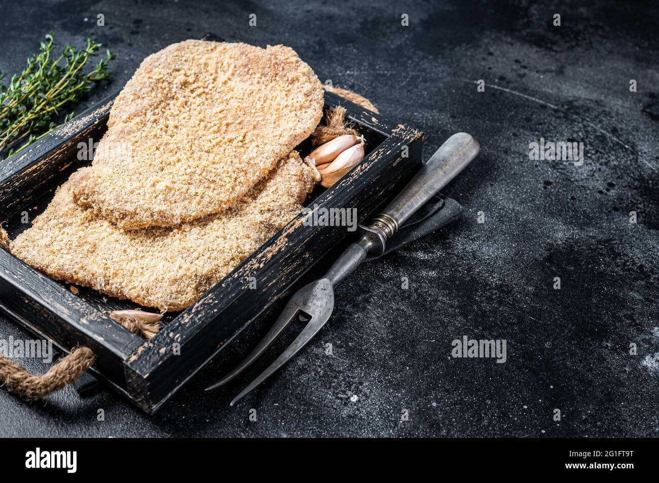 Homemade German Wiener Raw schnitzel in a wooden tray. Black background ...
