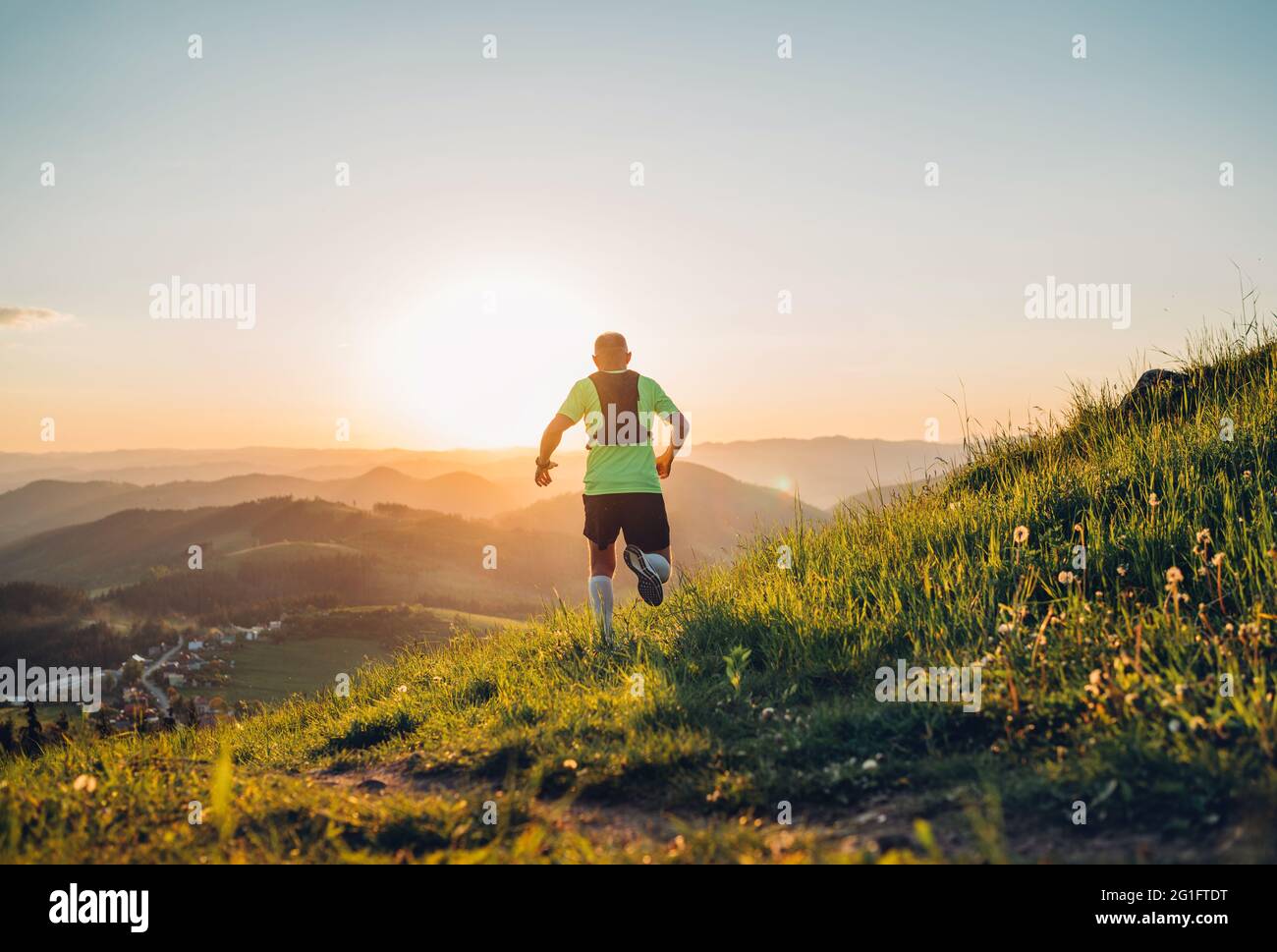 Active mountain trail runner dressed bright t-shirt with backpack ...