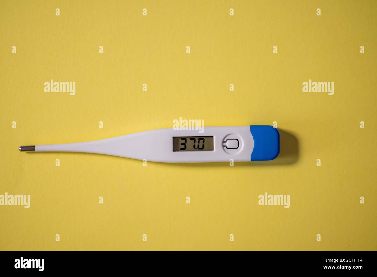 Digital thermometer shot from directly above against yellow background ...