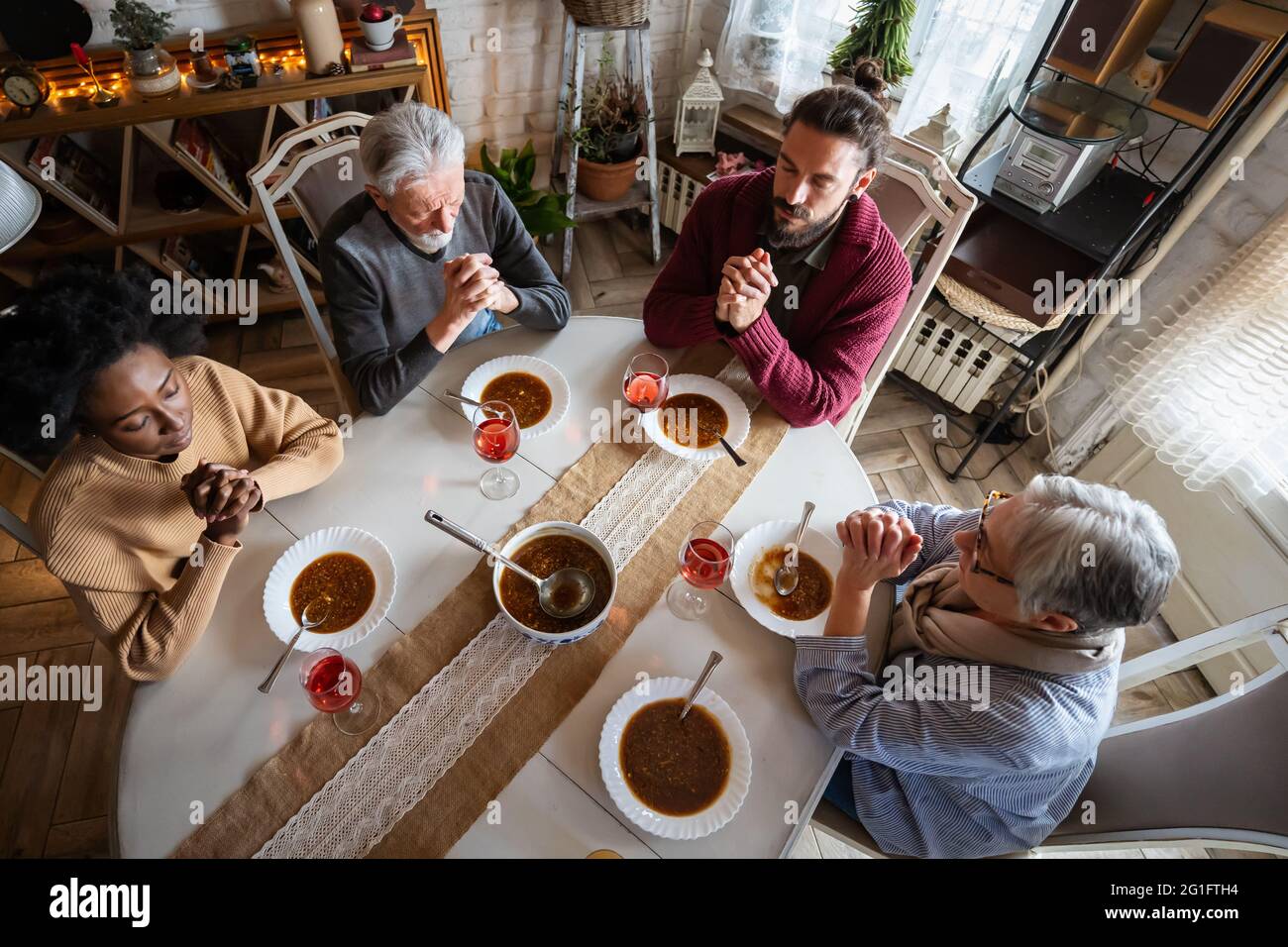 Multiethnic family praying at the table worshipping the Lord Stock ...