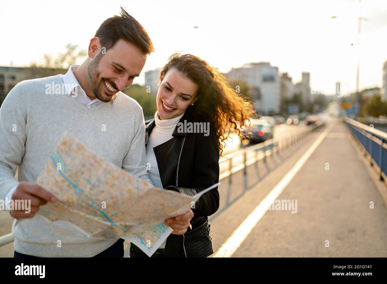 Happy couple tourists sightseeing city with map. People, travel concept ...