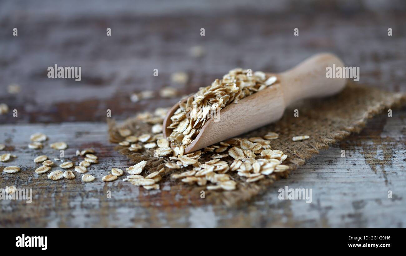 Oatmeal on wooden background in a wooden spatula Stock Photo - Alamy