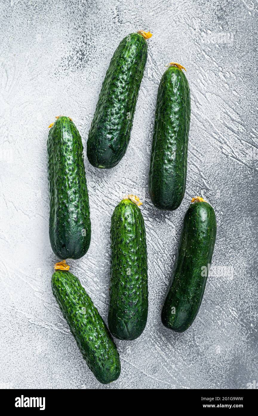 Organic Green Cucumbers on a kitchen table. White background. Top view ...